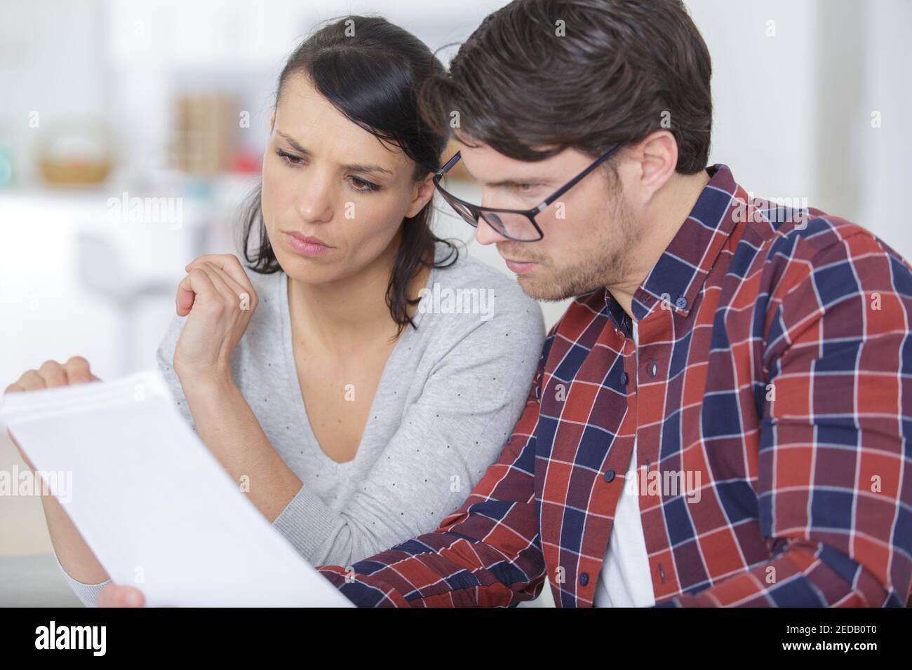 couple reading papers on couch Stock Photo - Alamy