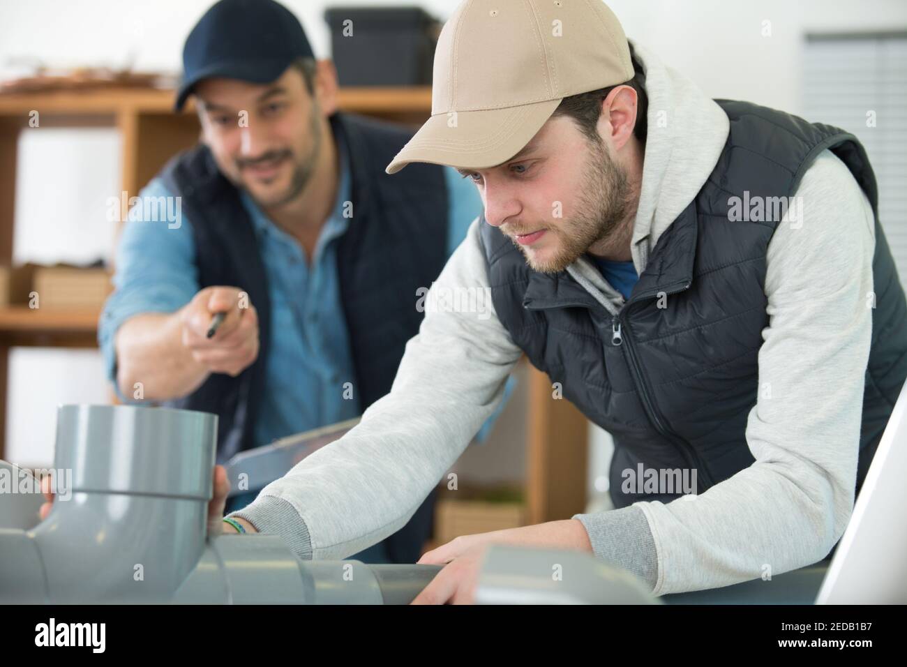 apprentice plumber connecting water fittings Stock Photo - Alamy