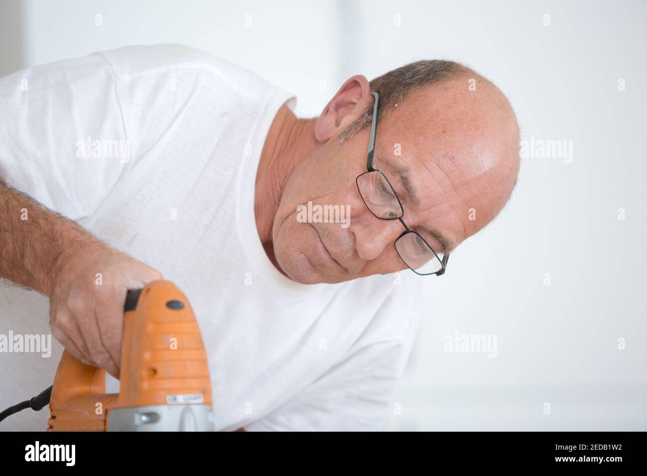 man cutting wood plank using electric jig saw Stock Photo - Alamy