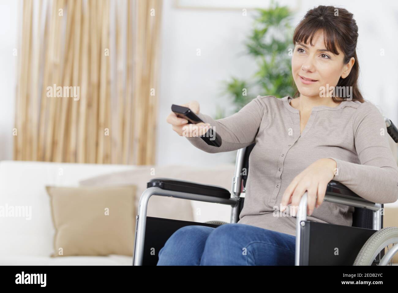 handicapped woman pressing the remote Stock Photo - Alamy