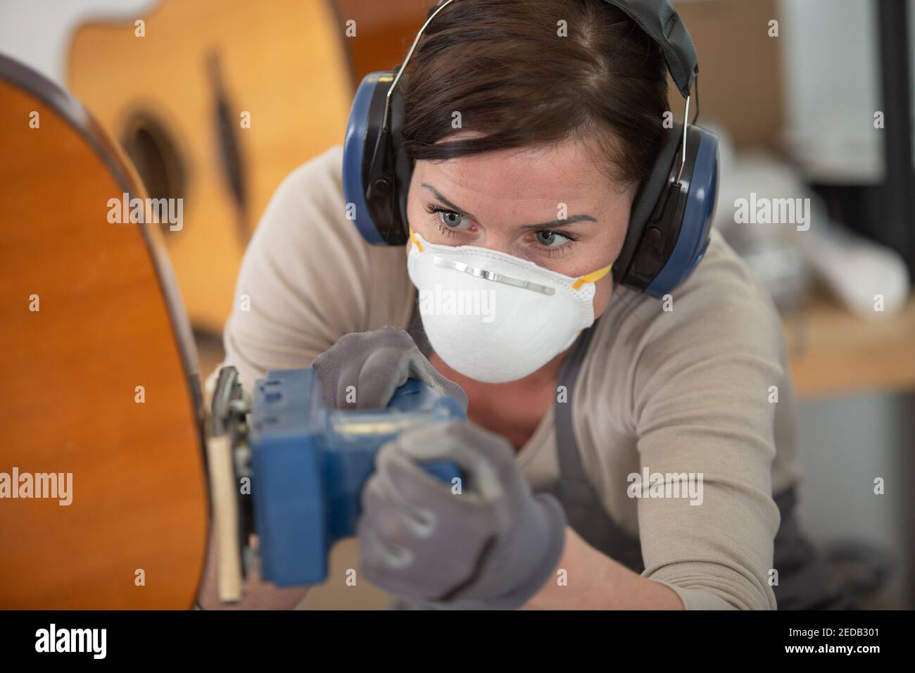 woman repair guitar with electric sander Stock Photo - Alamy