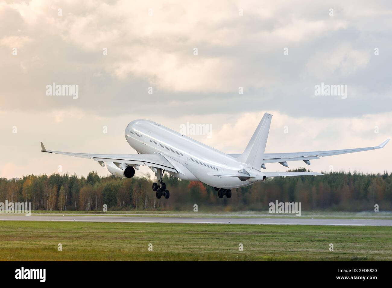 Wide-body modern passenger airplane fly up over take off runway from airport Stock Photo - Alamy