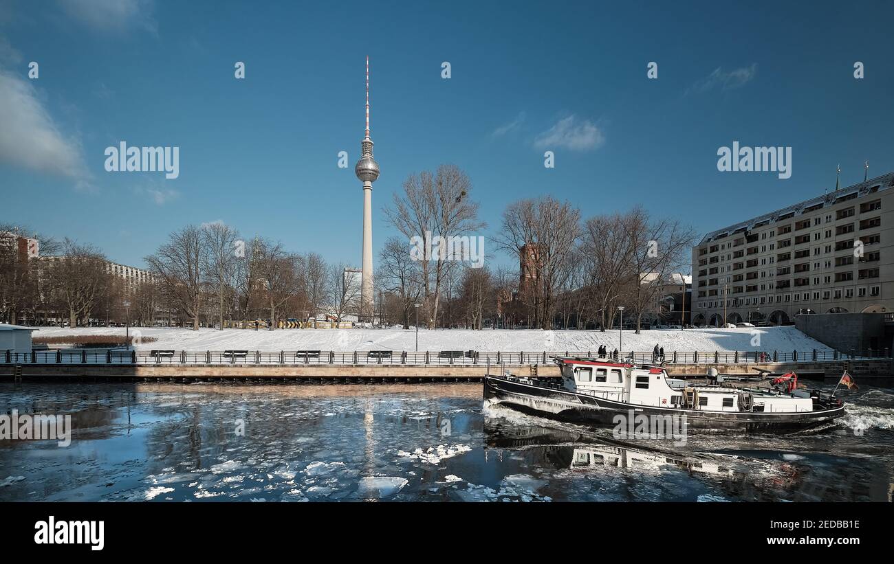 Berlin riverside in winter. Boat crashes ice on Spree river. Panoramic ...