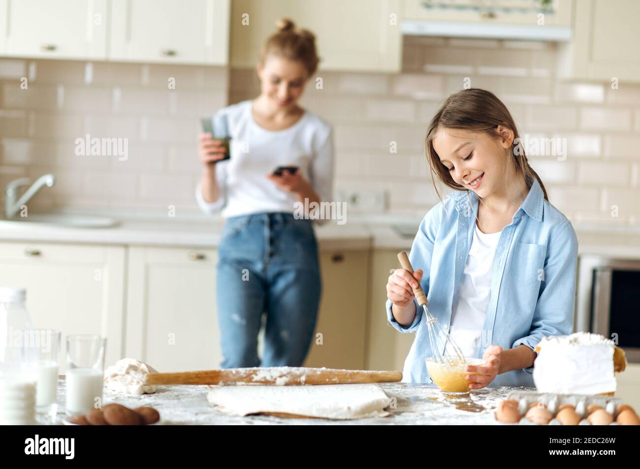 Mom's little helper. A cute caucasian little girl learns to cook a pie ...