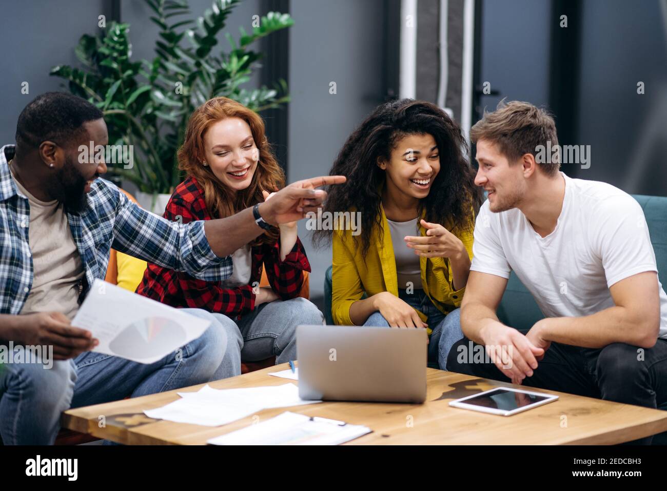 Friendly multiracial business colleagues sitting in office, talking ...