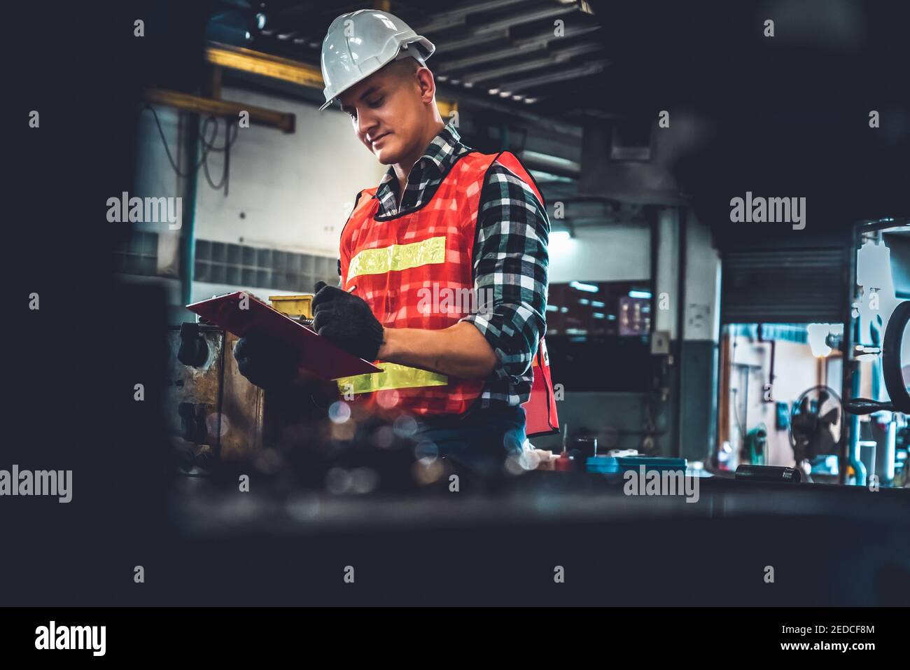 Manufacturing worker working with clipboard to do job procedure ...