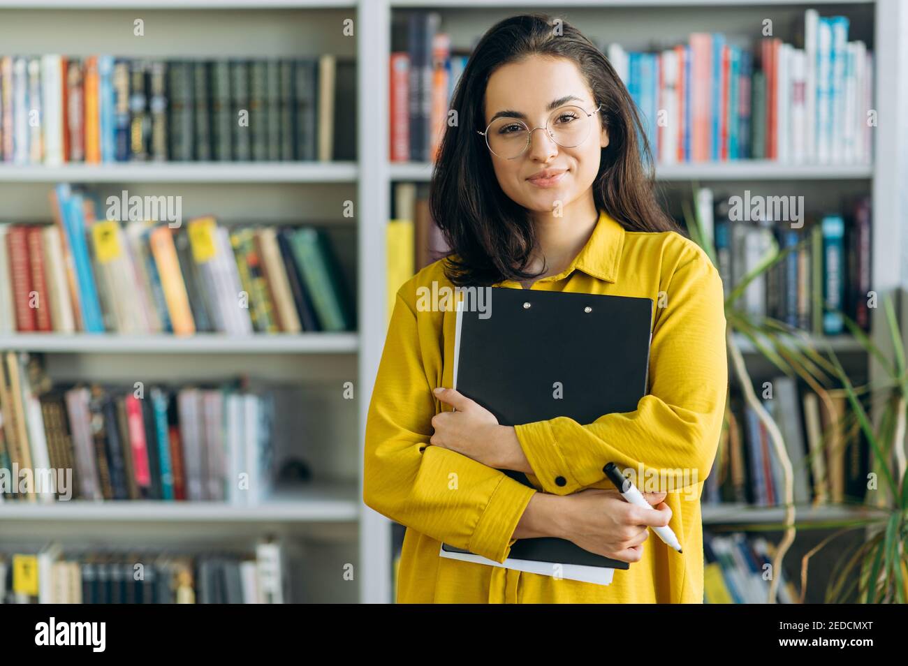 Portrait of happy attractive female teacher or employee in eyeglasses ...