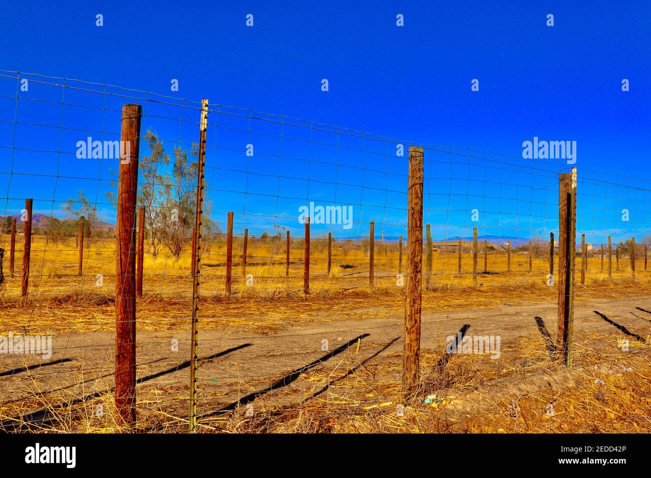 Rustic fence with rural desert landscape Stock Photo - Alamy