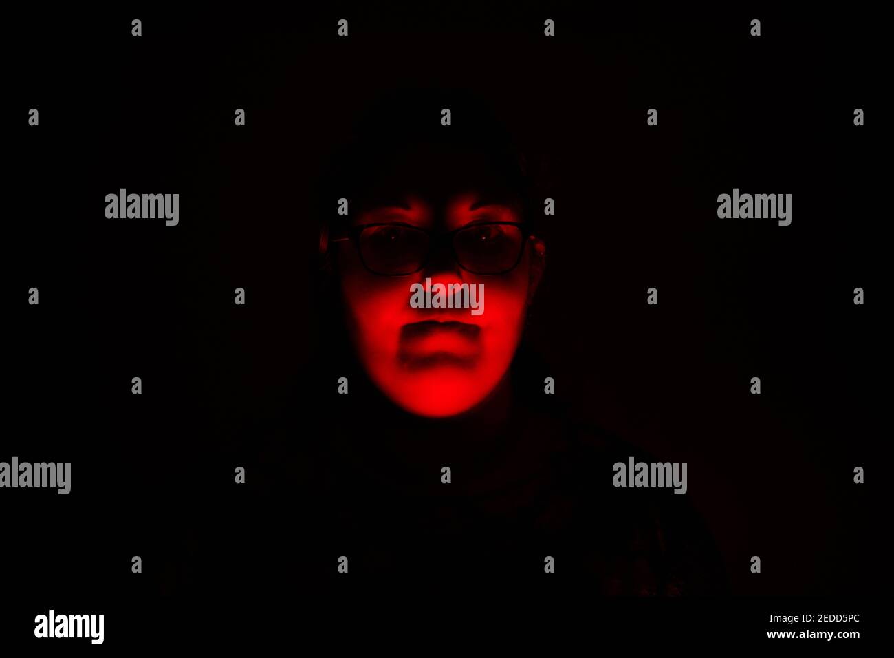 woman with dark background and scary red light Stock Photo - Alamy