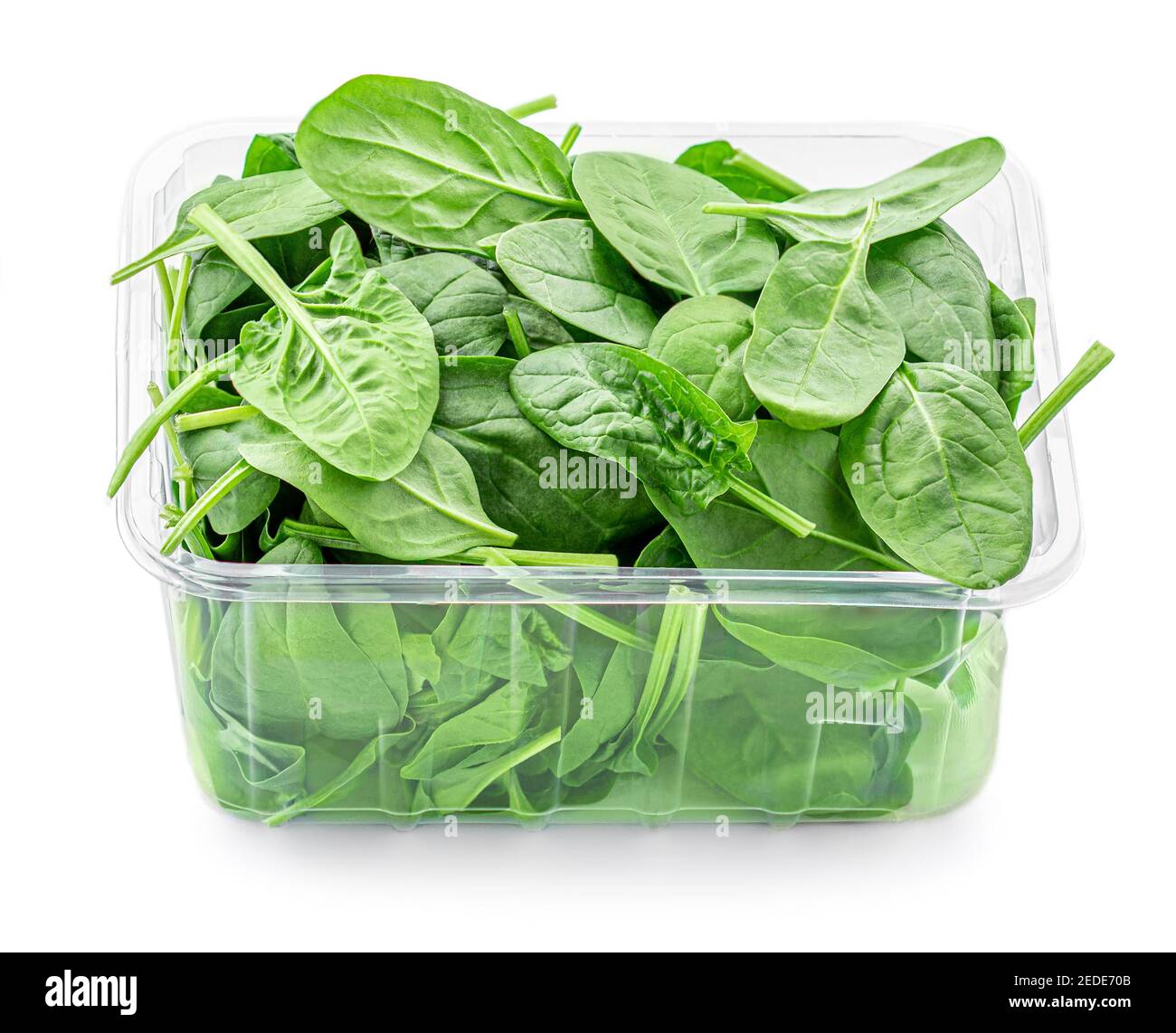 Spinach leaves in a plastic package isolated on white background. Green ...