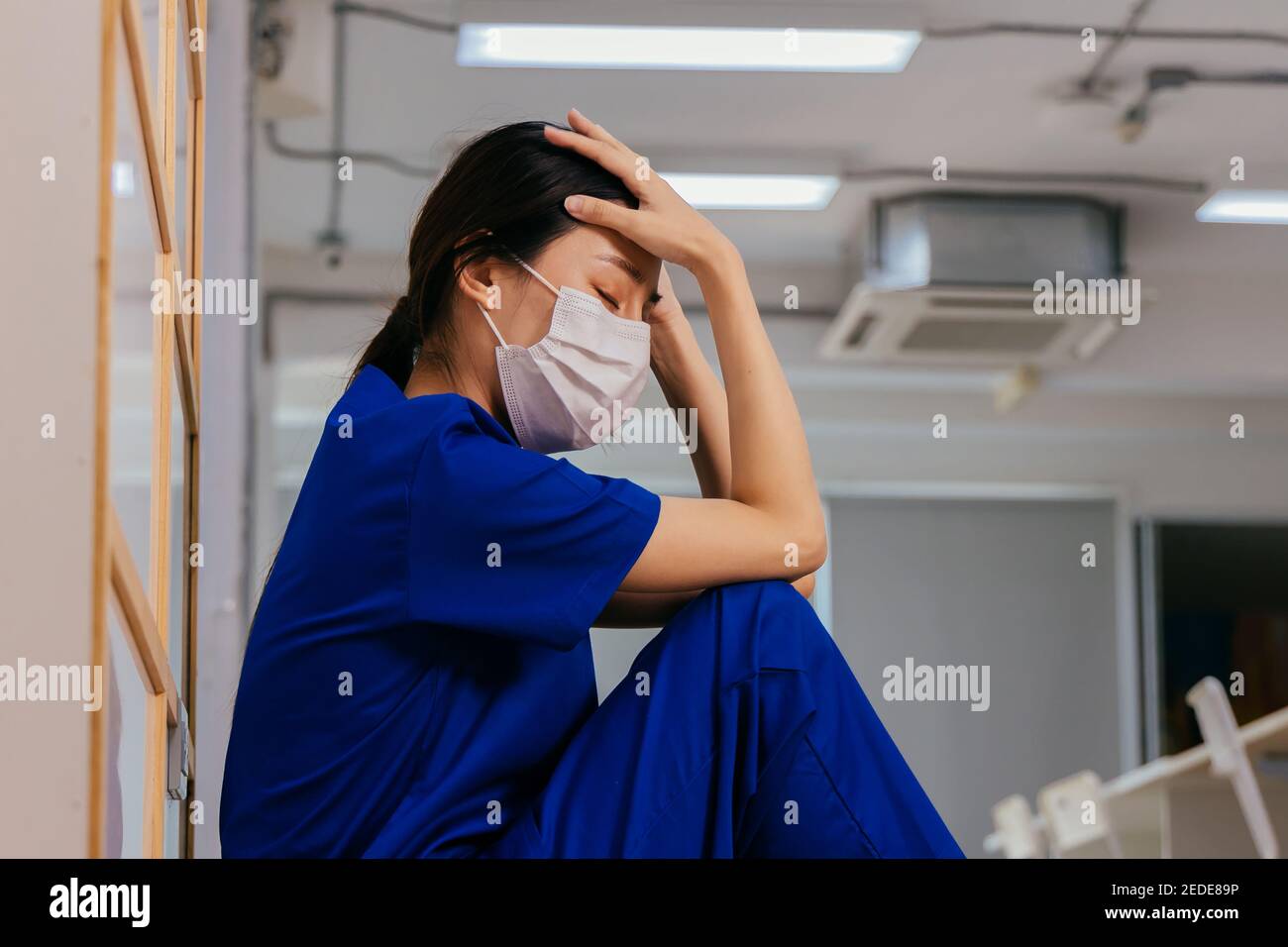 Young Asian woman nurse wearing uniform and surgical mask looking ...