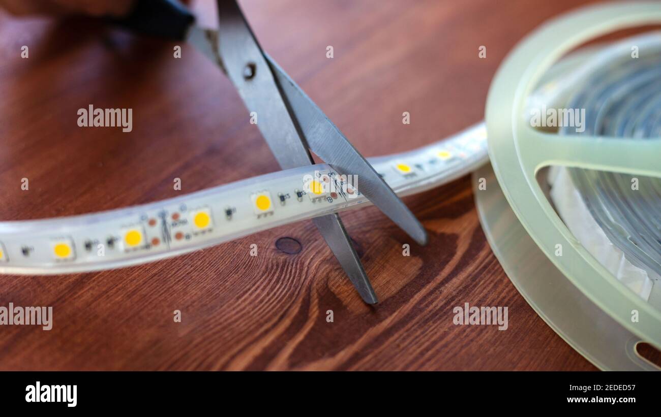 cut the LED strip with scissors closeup Stock Photo - Alamy