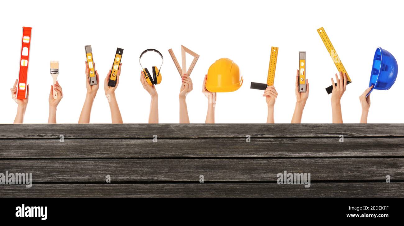 Female hands with different construction tools and wooden surface on ...