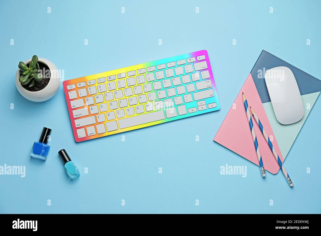 Colorful computer keyboard with mouse, stationery and nail polishes on ...