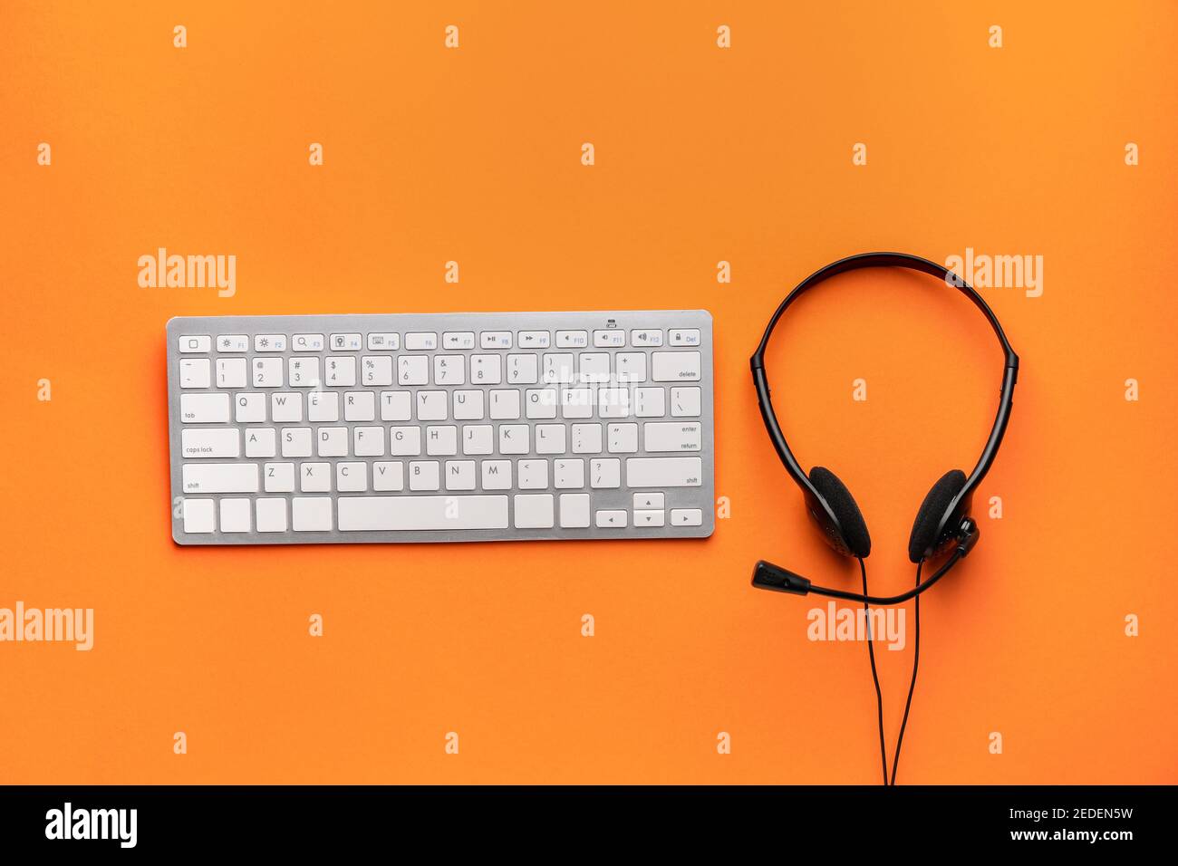 Headset with computer keyboard on color background Stock Photo - Alamy