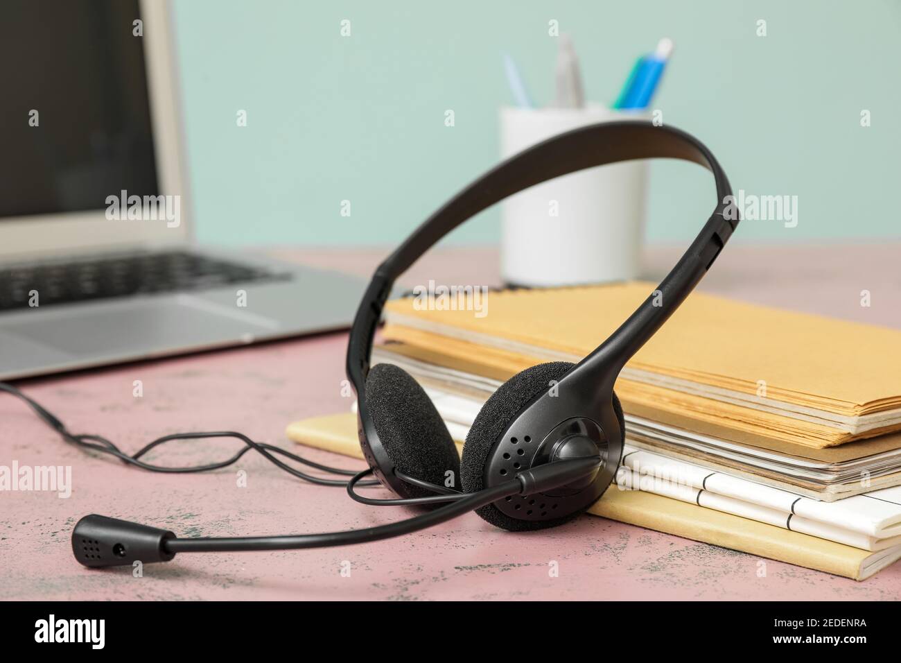 Headset with notebooks on table in office Stock Photo - Alamy