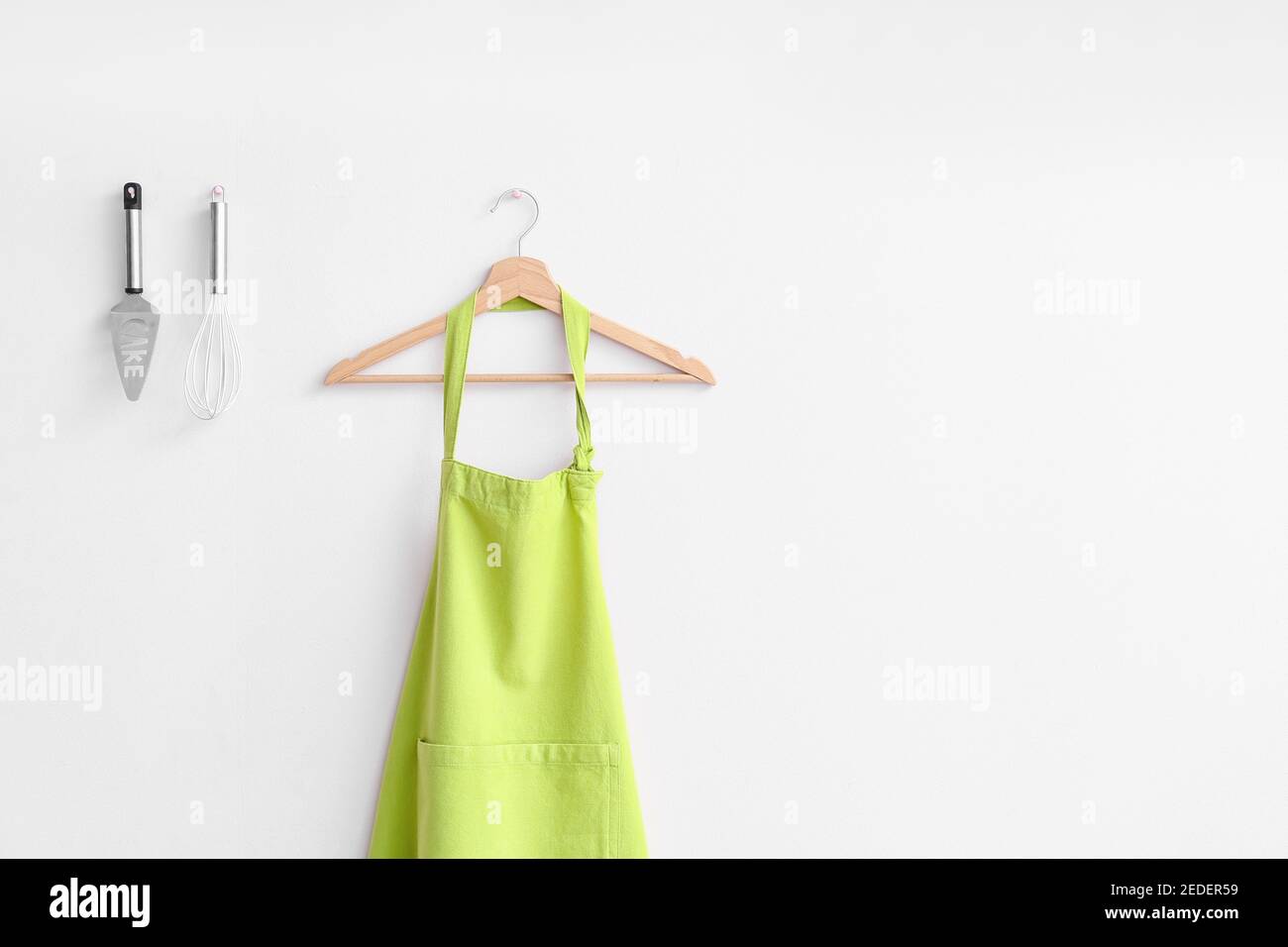 Clean apron and kitchen utensils on light background Stock Photo - Alamy