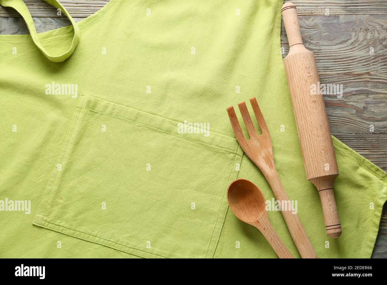 Clean apron and kitchen utensils on wooden background, closeup Stock ...