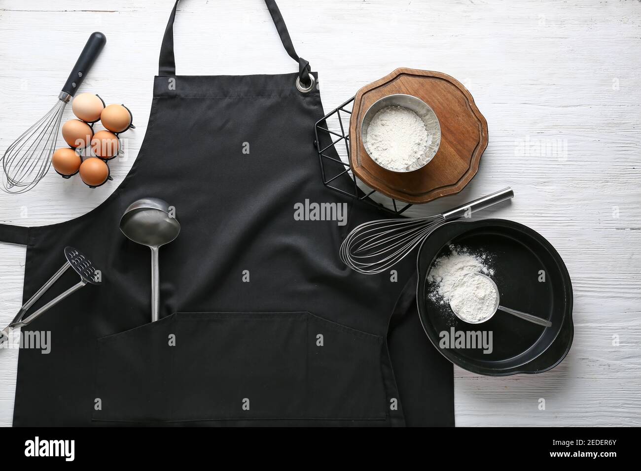 Clean apron, kitchen utensils and ingredients on light background Stock ...