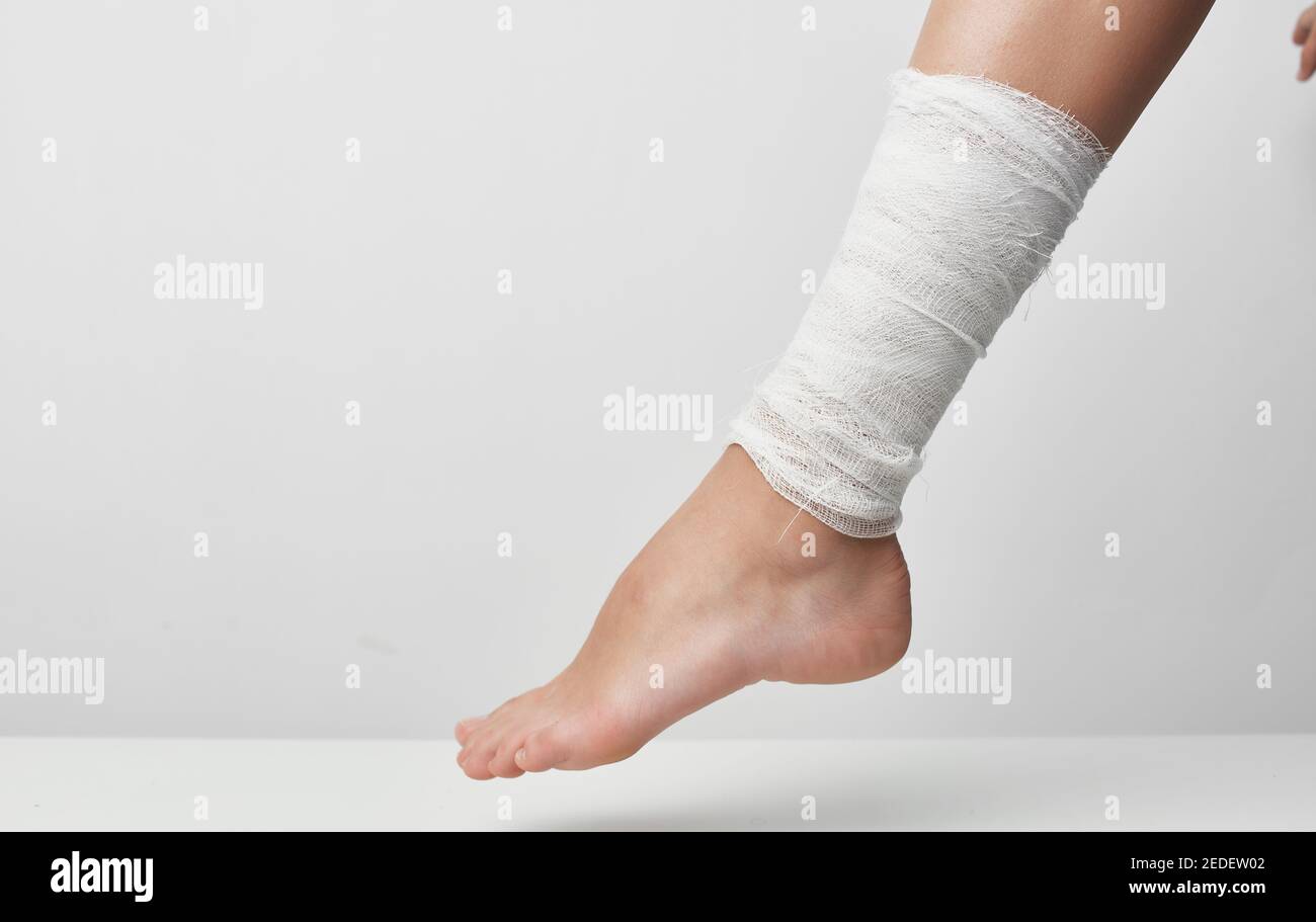 bandaged leg injury medicine gray background problems Stock Photo - Alamy