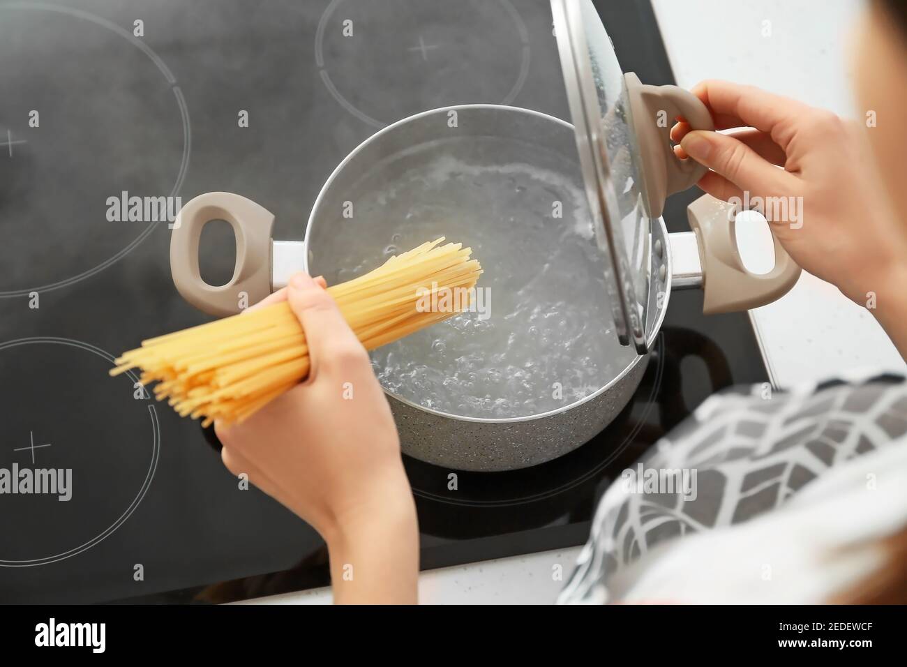 Woman cooking tasty pasta in kitchen Stock Photo - Alamy