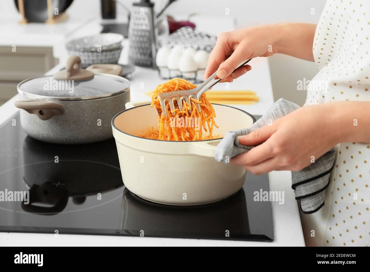 Woman cooking tasty pasta in kitchen Stock Photo - Alamy