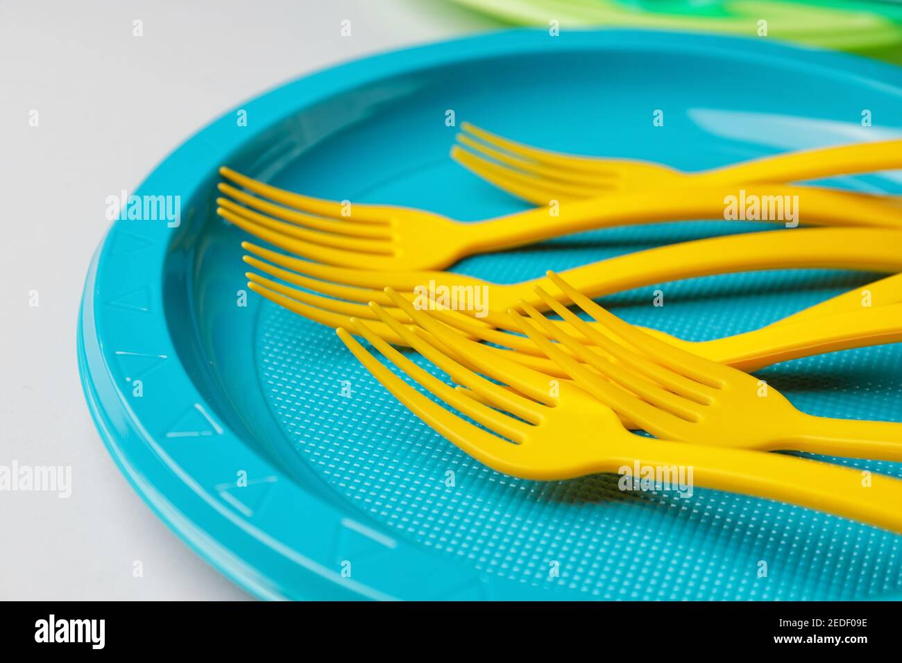 Plastic forks and plate on light background Stock Photo - Alamy
