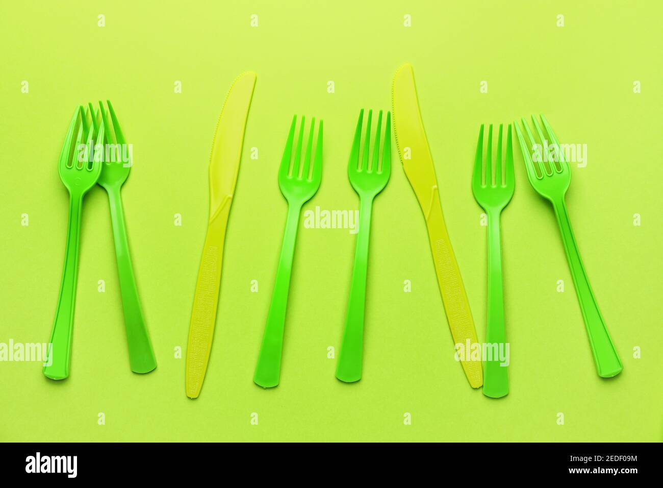 Plastic forks and knives on color background Stock Photo - Alamy