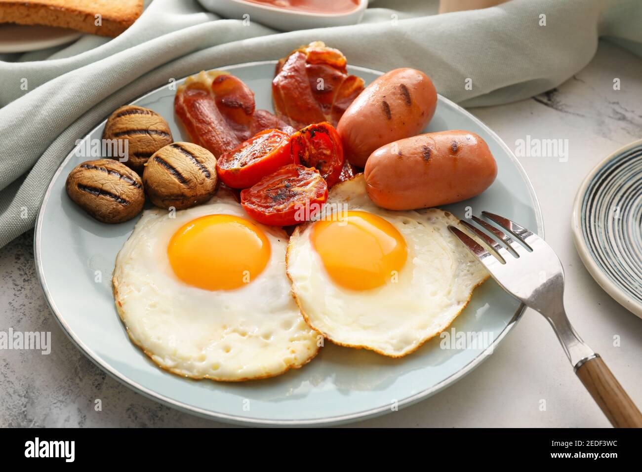 Traditional English breakfast with fried eggs on light background Stock ...