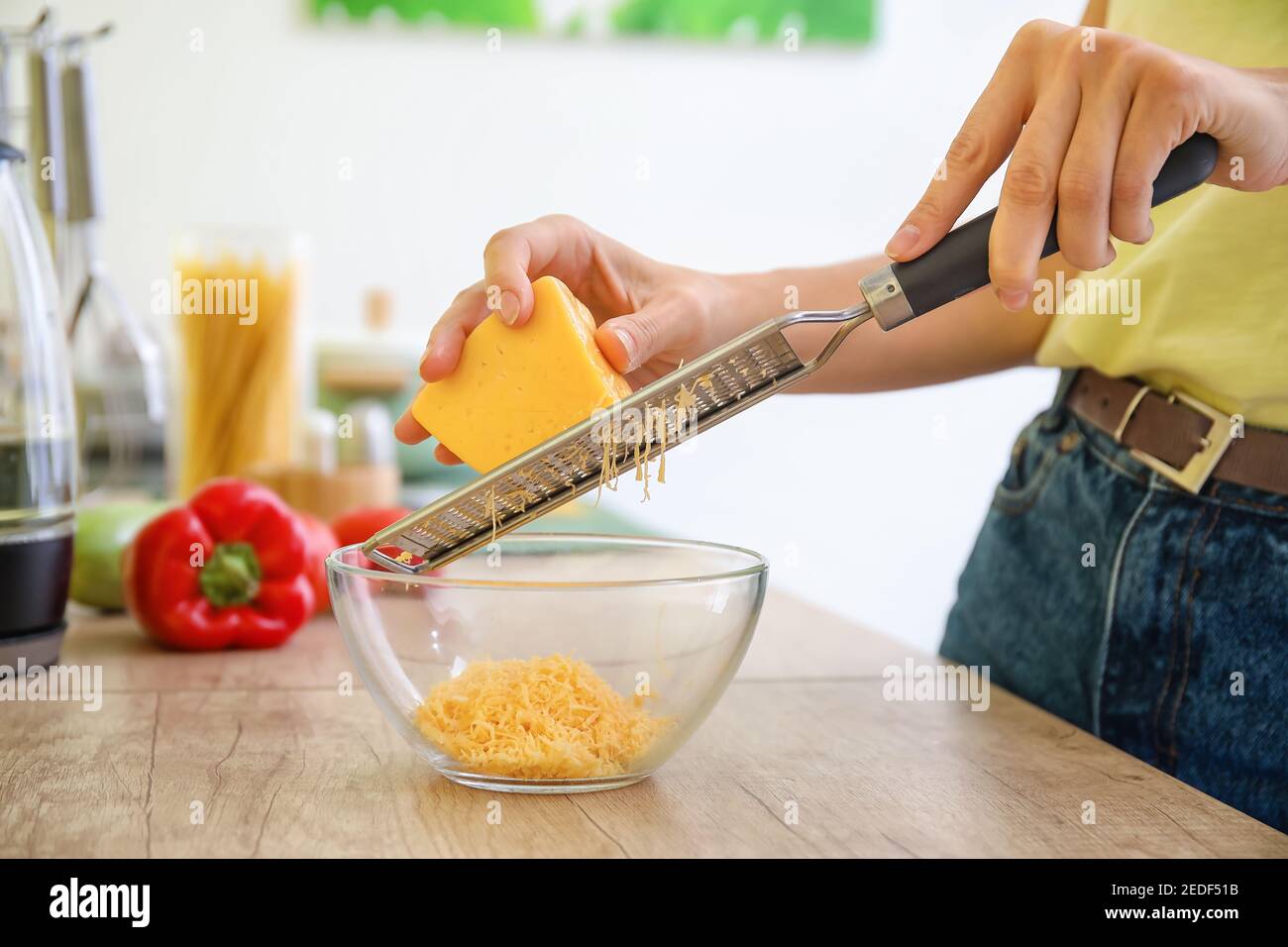Woman grating cheese in kitchen Stock Photo - Alamy