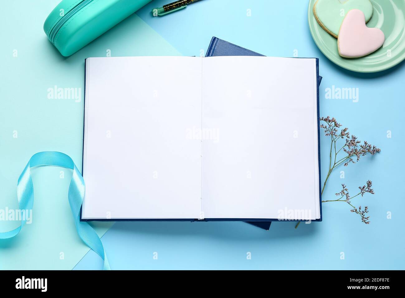 Blank book, cookies and ribbon on color background Stock Photo - Alamy