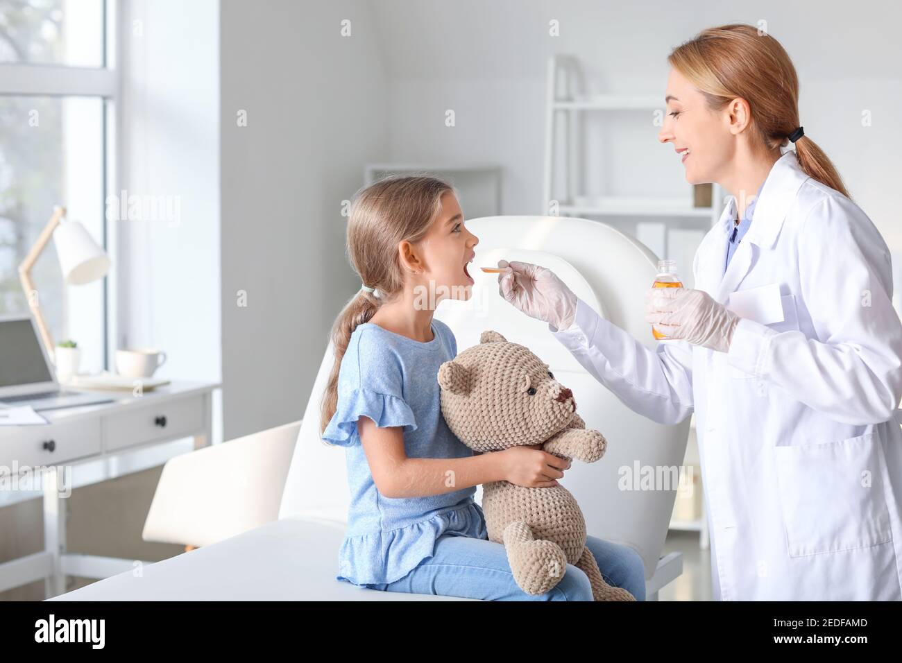 Pediatrician giving medicine to little girl in clinic Stock Photo - Alamy