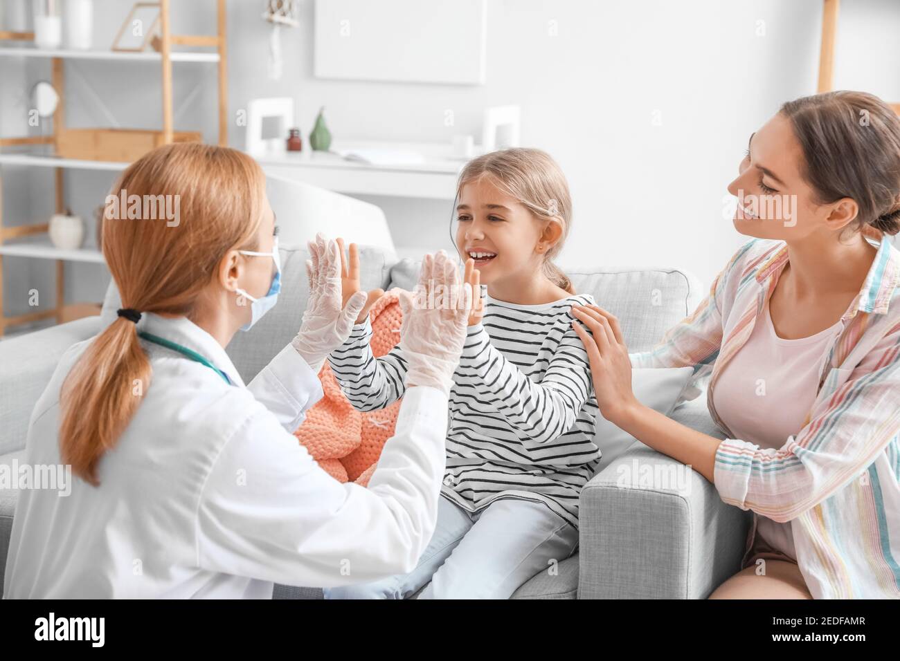 Pediatrician examining little girl at home Stock Photo - Alamy