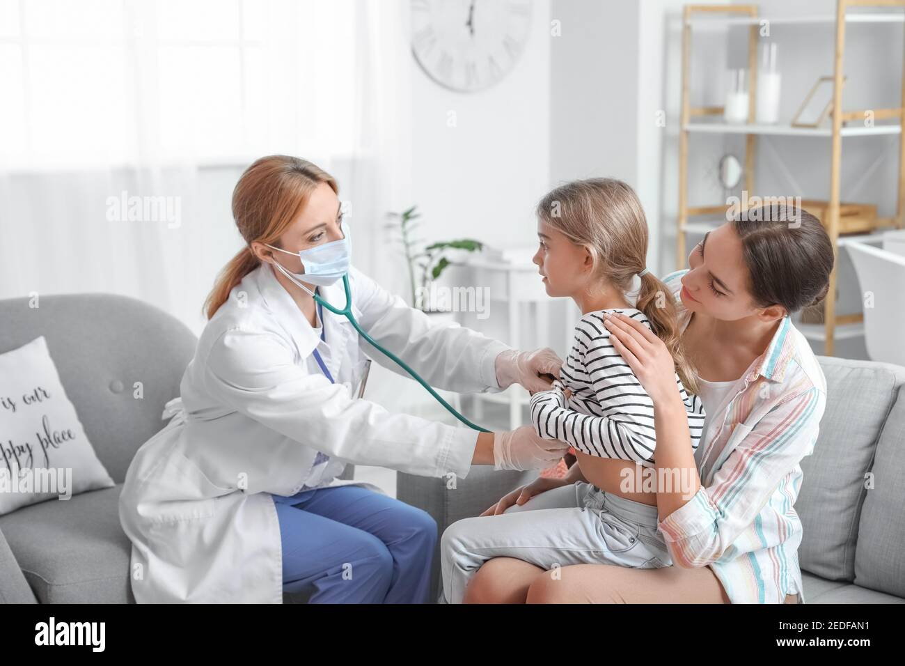 Pediatrician examining little girl at home Stock Photo - Alamy