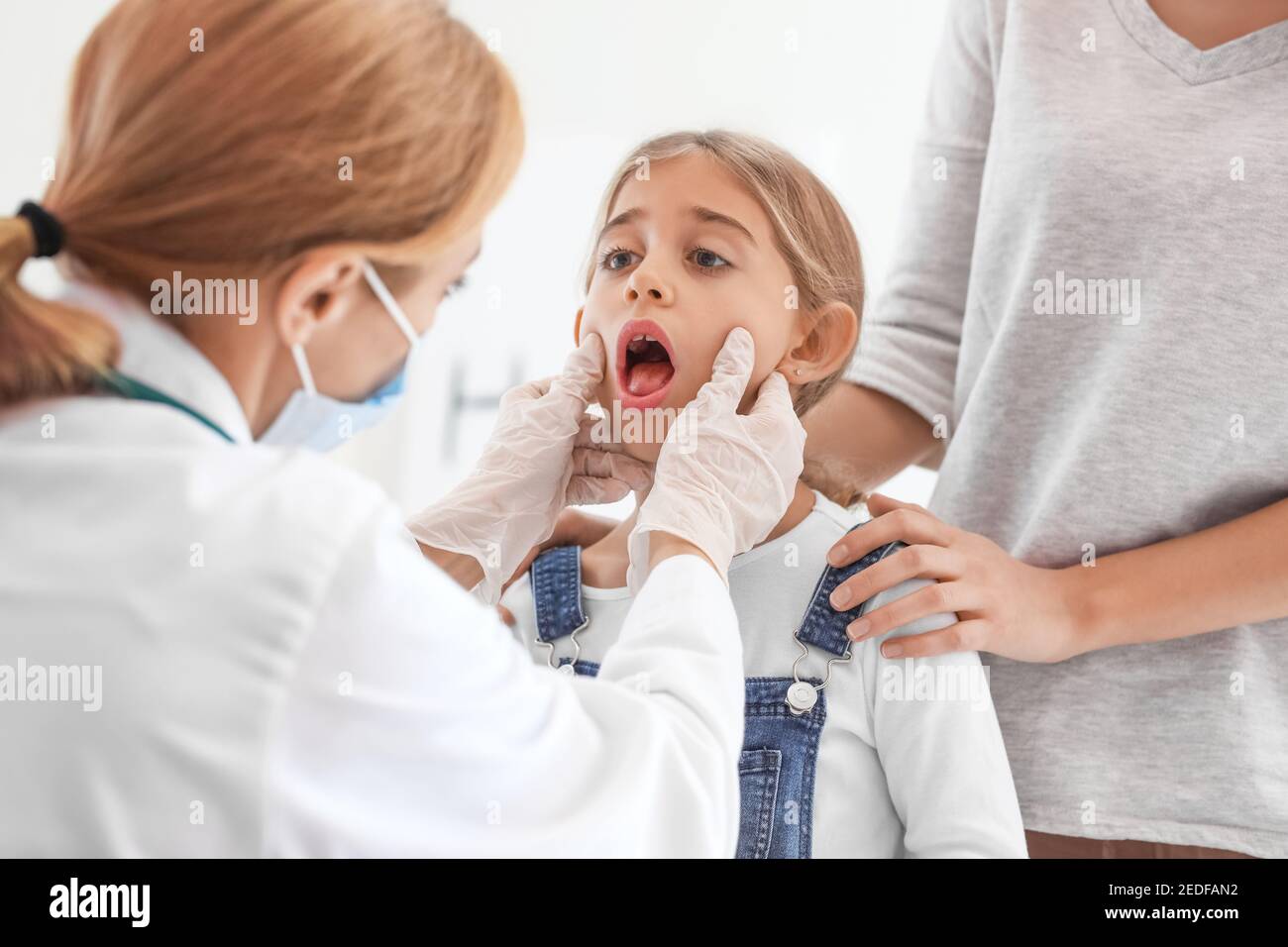 Pediatrician examining little girl at home Stock Photo - Alamy