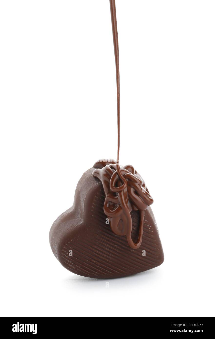 Pouring of melted chocolate on candy against white background Stock ...