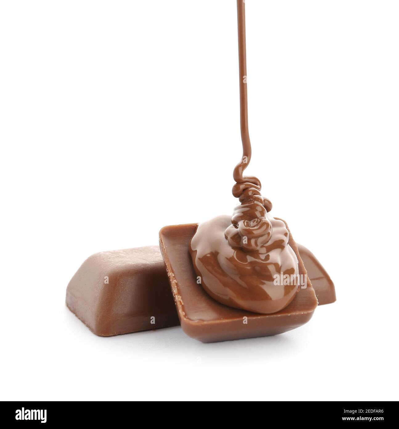 Pouring of melted chocolate on candies against white background Stock ...