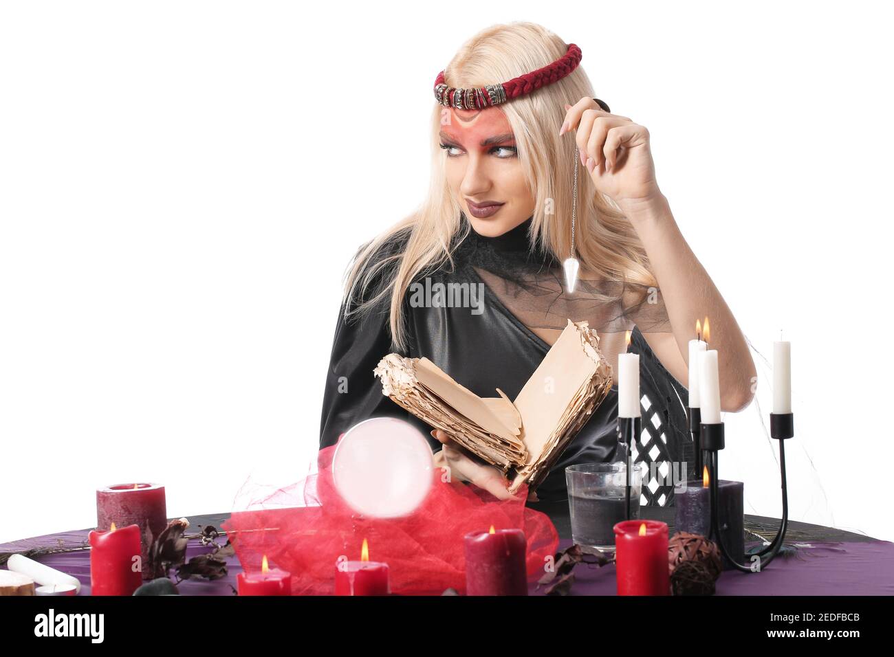 Scary young witch with spell book on white background Stock Photo - Alamy