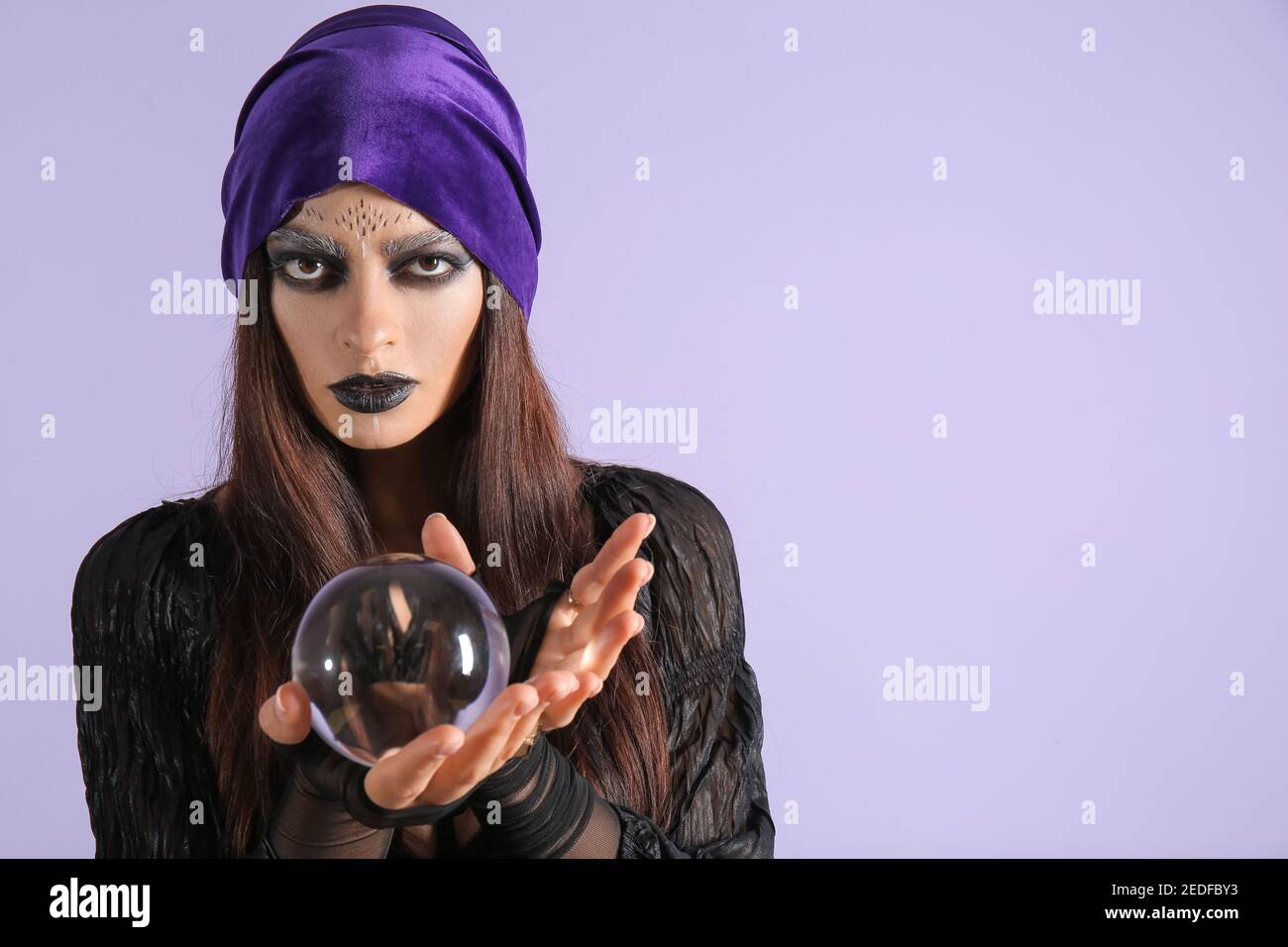Fortune teller with crystal ball on color background Stock Photo - Alamy