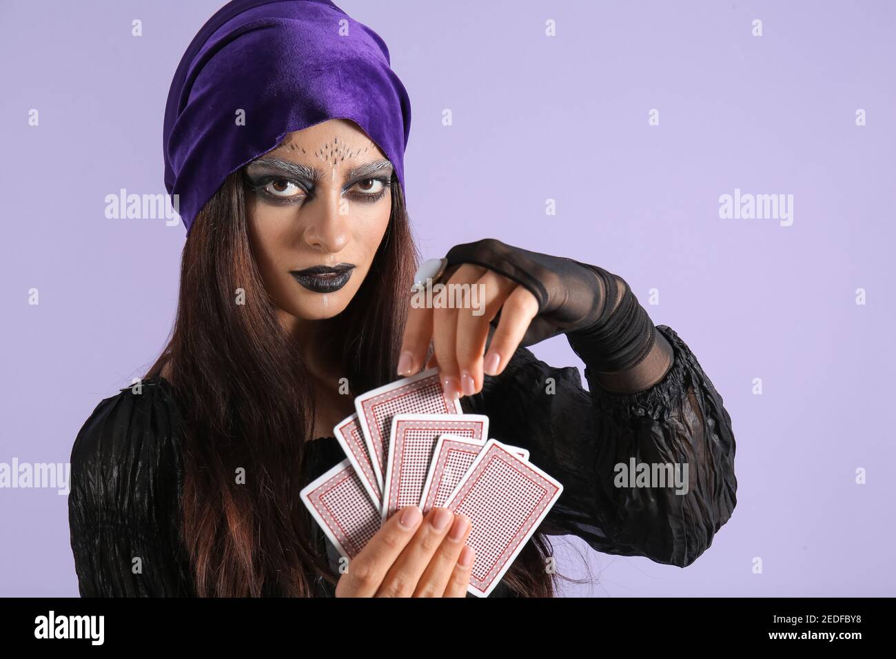 Fortune teller with cards on color background Stock Photo - Alamy