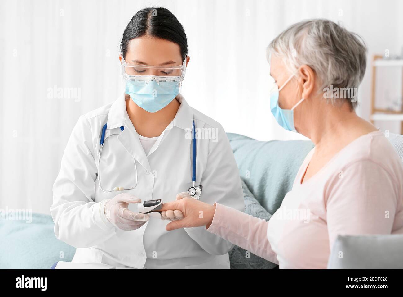 Doctor measuring oxygen saturation level of patient blood at home Stock ...