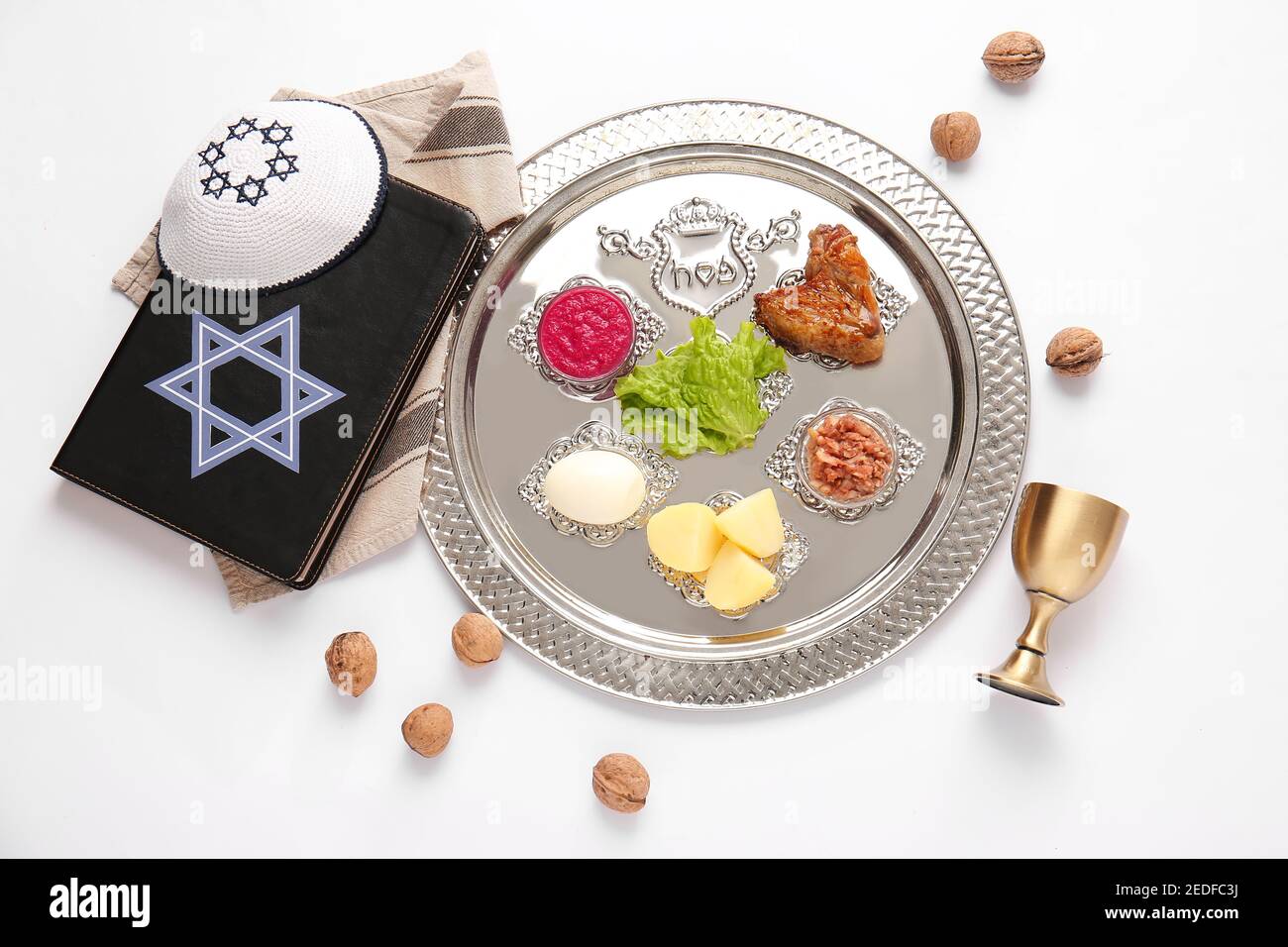 Passover Seder plate with traditional food, Torah and Jewish cap on ...