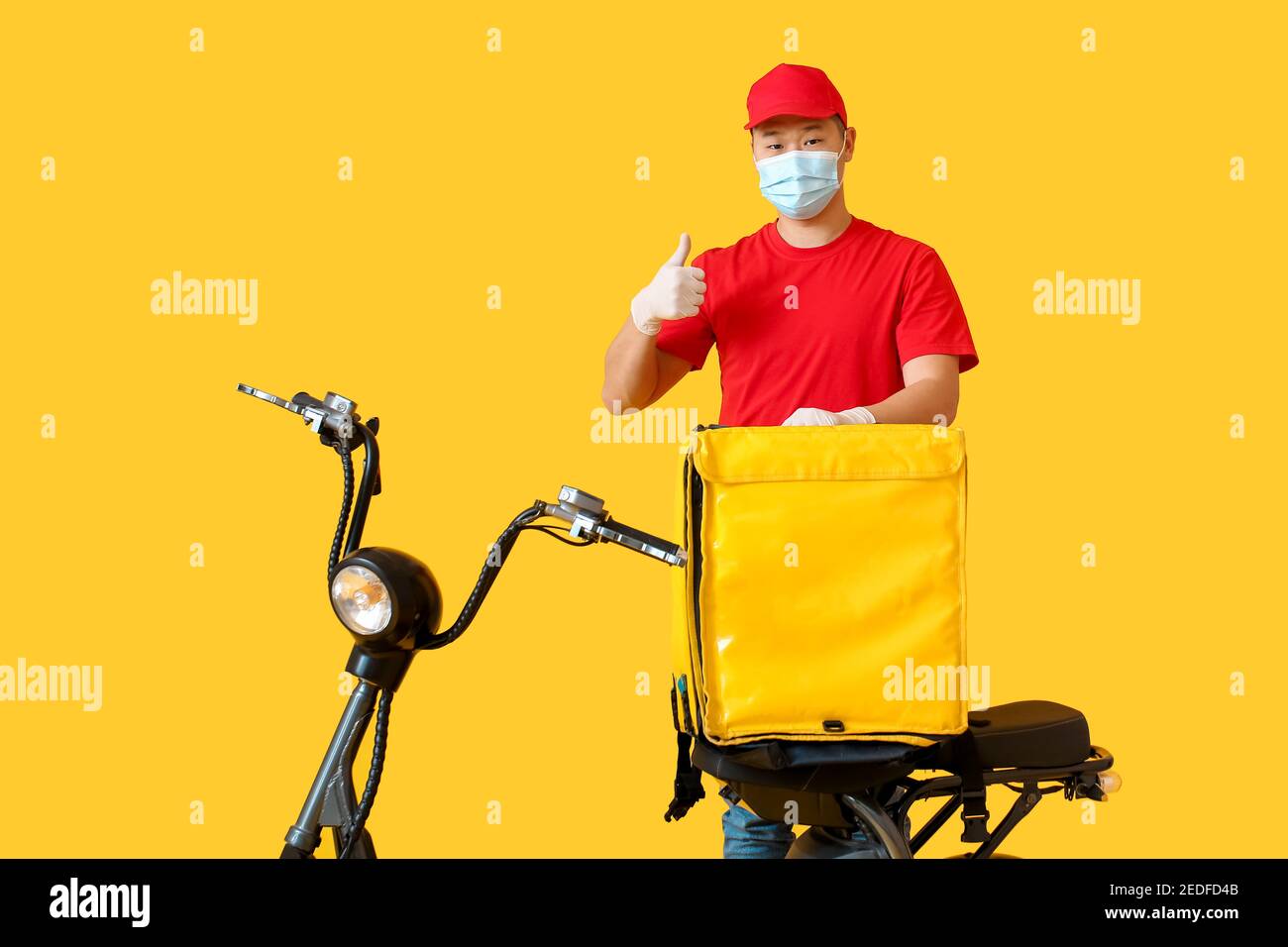 Courier of food delivery service showing thumb-up on color background ...