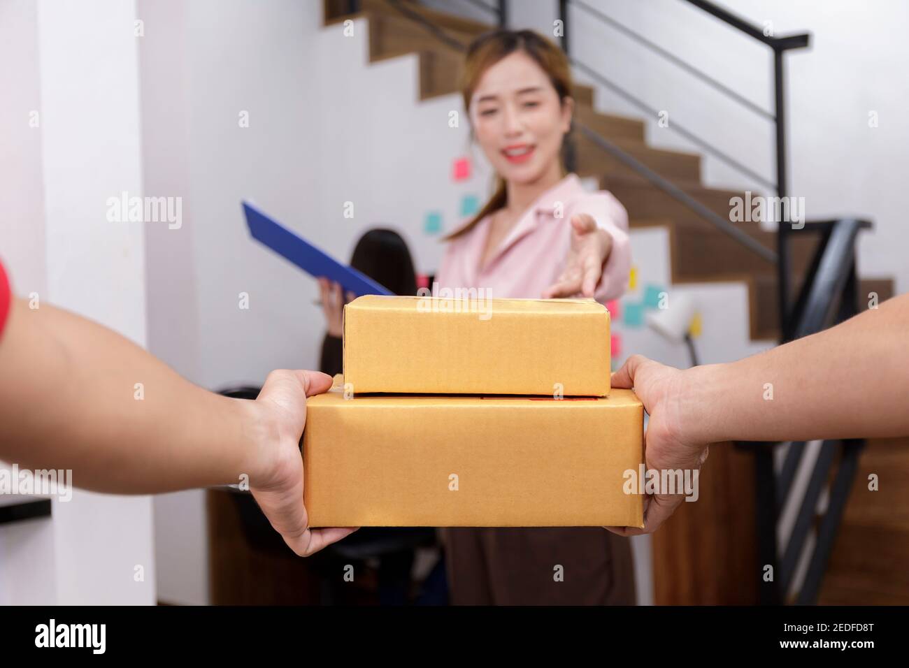 Hand of delivery man delivering package to homeowner. Woman accepting a ...