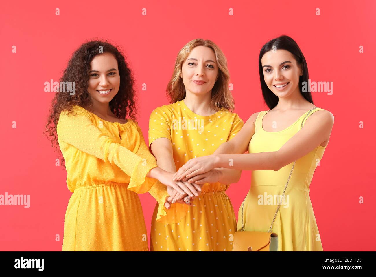 Beautiful women putting hands together on color background. Unity ...