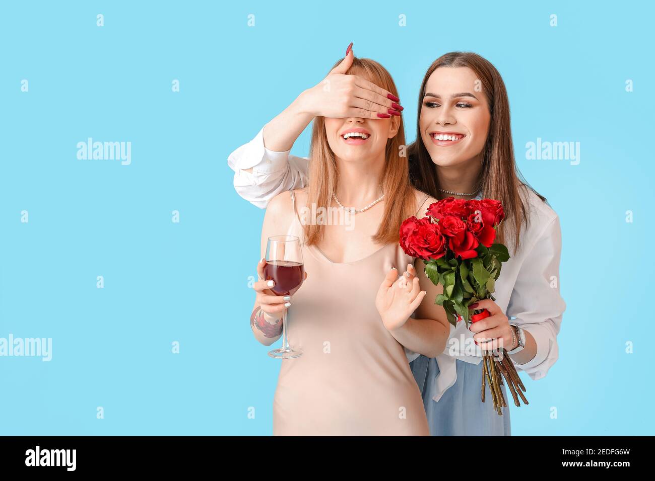 Young transgender woman greeting her girlfriend on color background ...