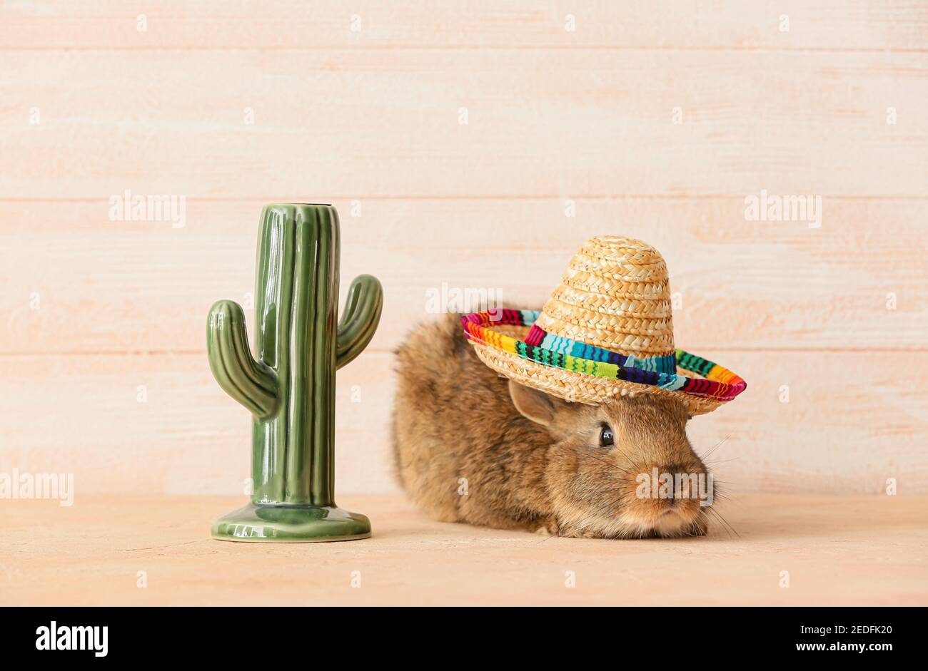 Cute fluffy rabbit with sombrero hat on light wooden background Stock ...