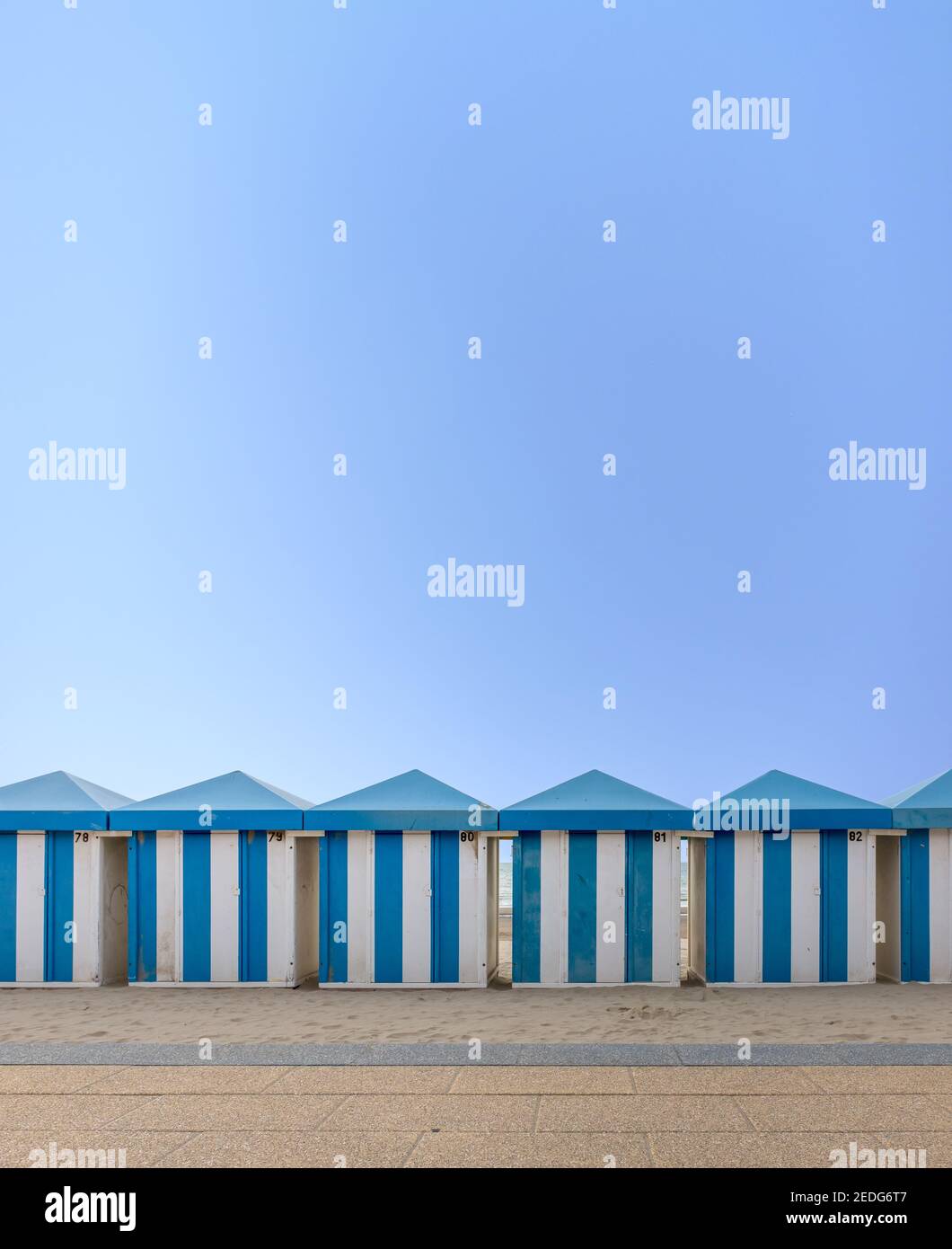 Vintage blue and white striped beach huts against clear sky. Copy space ...