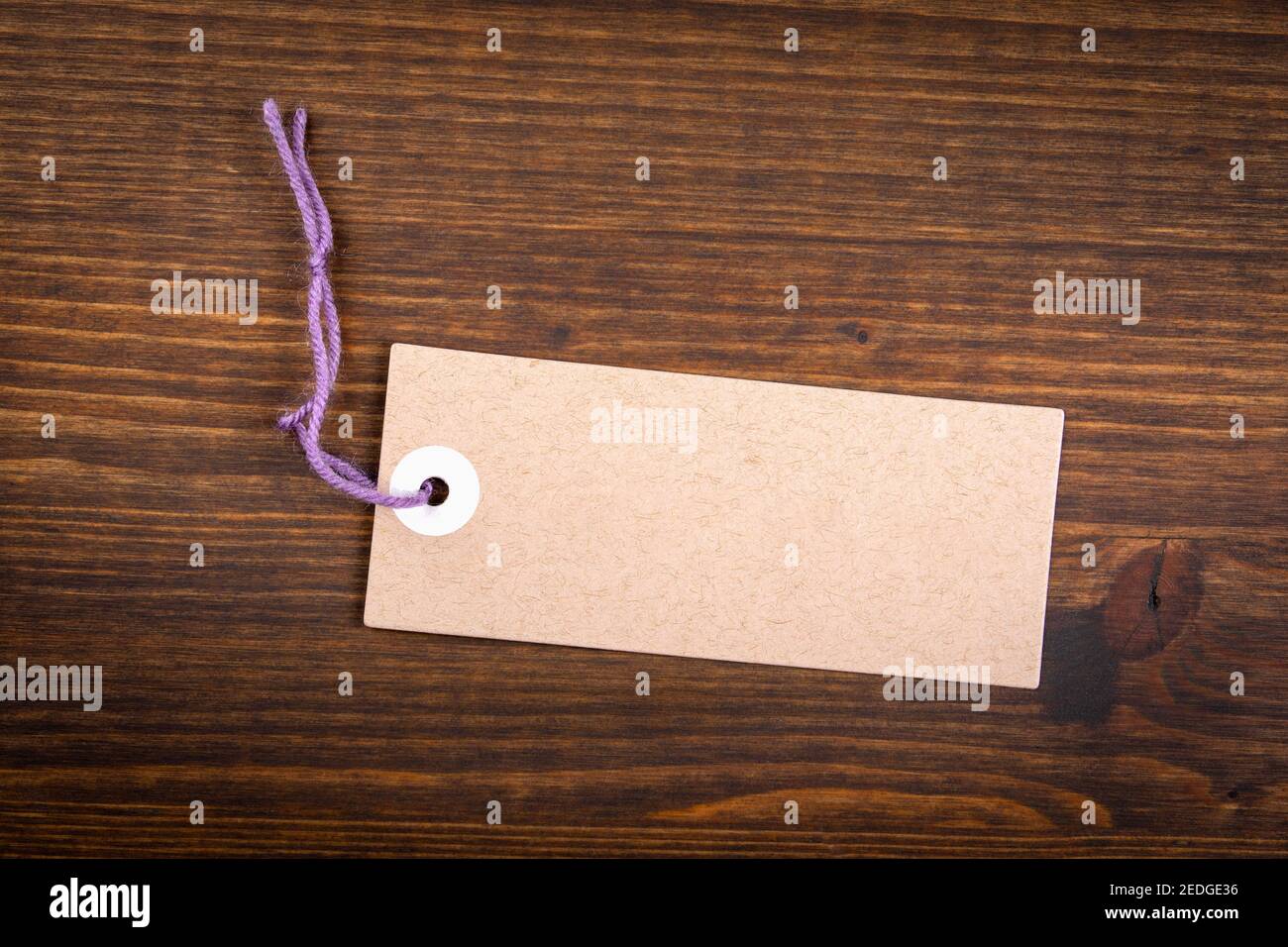 Cardboard price tag with purple cord on a dark wooden background Stock ...