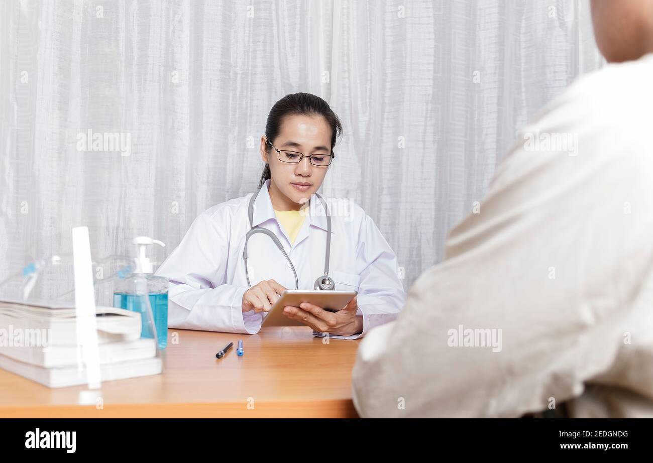 Doctor working in her clinic and listening and analysis to the patient ...